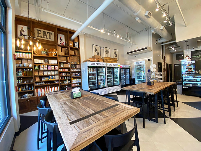 Edison bulbs illuminate wooden communal tables where strangers become friends over exceptional sandwiches. The black and white floor says "classic," but the vibe says "welcome."