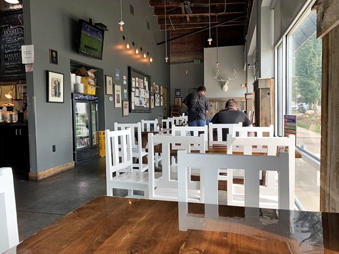 White chairs against slate-gray walls create the perfect canvas for culinary artistry. Even the mounted deer head seems impressed by what's happening here.