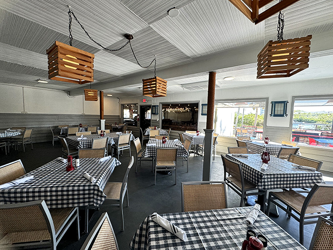 Black and white checkered tablecloths, wooden pendant lights, and an atmosphere that whispers, "Relax, you're about to experience lobster nirvana."