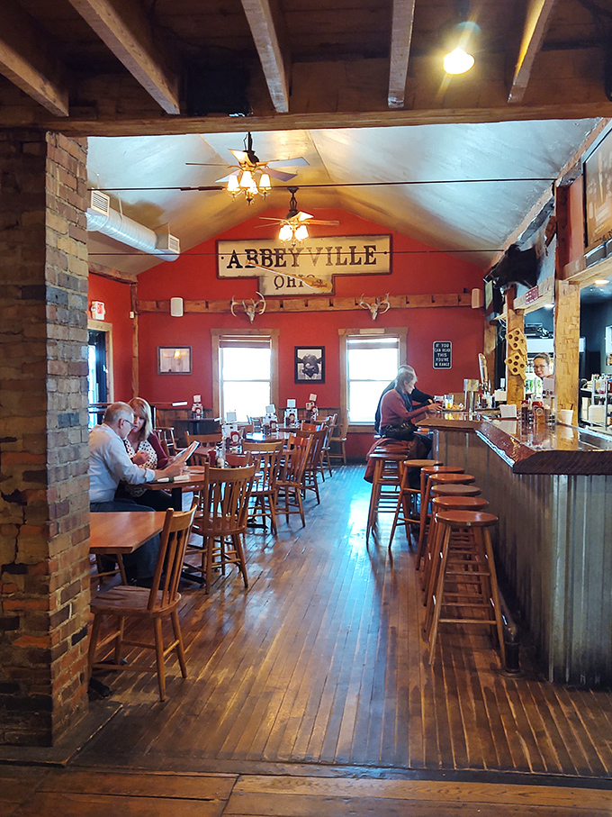Rustic charm meets barbecue paradise with wooden floors, exposed beams, and that "Abbeyville, OH" sign watching over happy diners.
