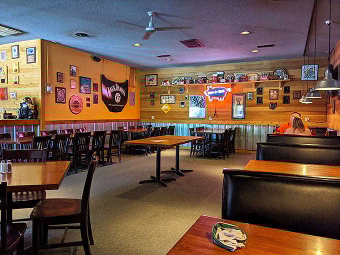 Wood-paneled walls adorned with awards tell stories of barbecue glory while that neon pig watches over diners like a smoky guardian angel.