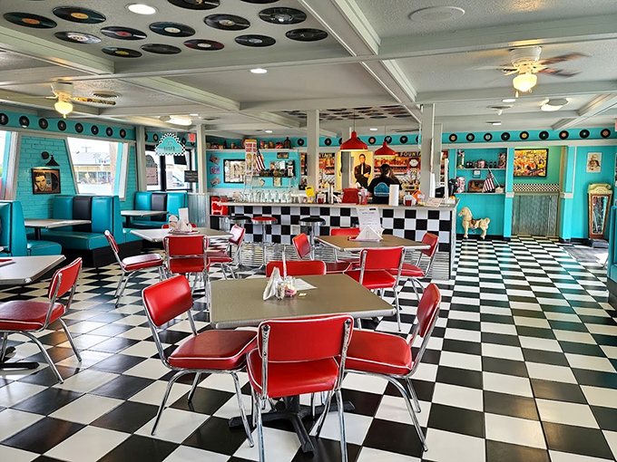 Step inside and the 1950s high-fives your eyeballs. Red vinyl chairs, checkered floors, and vinyl records on the ceiling create an authentic time-travel experience.