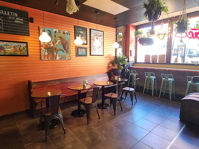 Orange walls, hanging plants, and metal chairs create that perfect "discovered gem" vibe&mdash;casual enough for breakfast, cool enough for a date night.