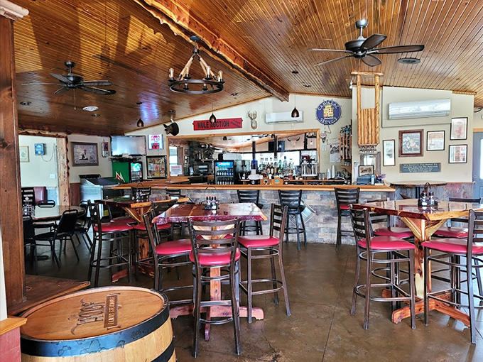 Warm wood paneling, wagon wheel chandeliers, and red-cushioned bar stools create the kind of cozy atmosphere where memories are made between bites.