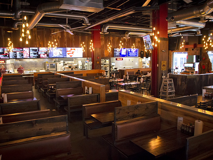 Rustic wooden booths under industrial chic lighting create the perfect setting for the serious business of barbecue consumption.