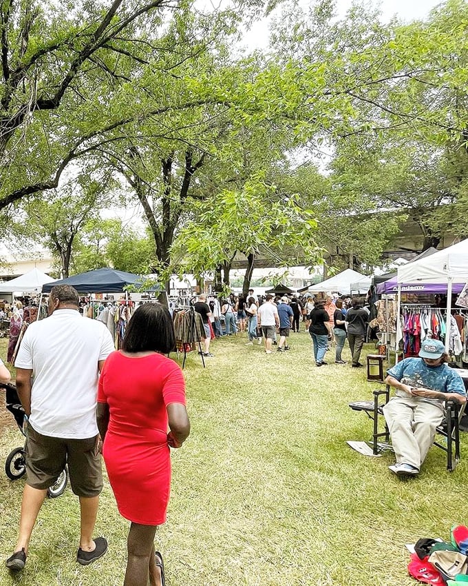 Treasure hunters navigate the outdoor market under a canopy of trees, where one person's castoffs become another's conversation pieces.