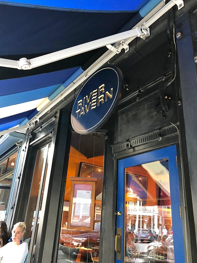 Classic blue awnings and a circular gold sign welcome you to a charming local eatery as you explore the town.