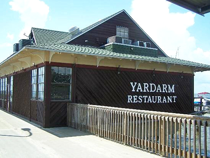 The Yardarm Restaurant sits perched on the water's edge, promising seafood so fresh it might have been swimming when you parked your car.