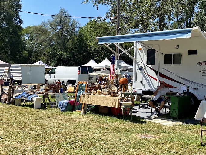 A vendor's RV becomes command central for a pop-up antique shop, where weathered treasures and vintage finds create an impromptu outdoor museum.