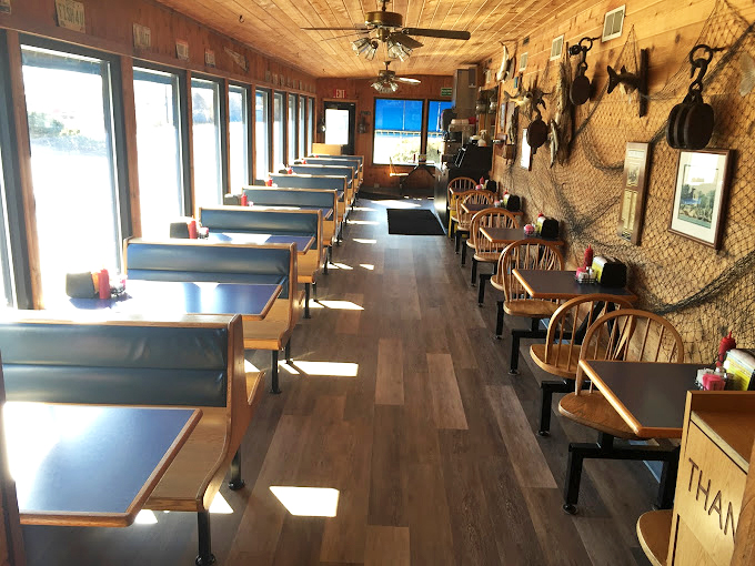 Nautical charm meets no-frills comfort in this wood-paneled dining room. Sunlight streams through windows, illuminating blue booths that have cradled countless happy diners.