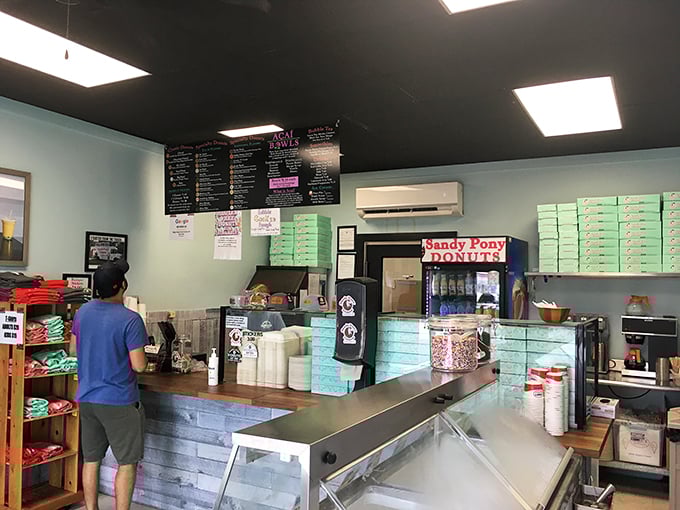 Behind the counter, where donut dreams become reality. The mint-colored walls and stacked boxes hint at the sweet treasures awaiting the patient pilgrim.