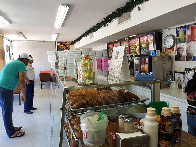 Behind the counter, where donut dreams become reality. Those apple fritters are calling my name louder than my cardiologist.