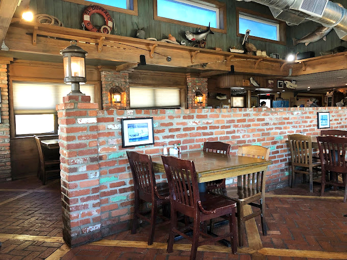Rustic brick walls and weathered wood create the perfect backdrop for seafood stories. This isn't décor—it's maritime history with tables.