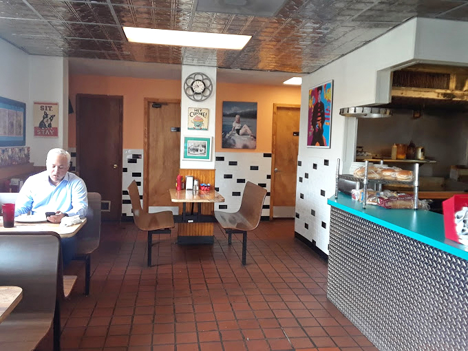 Inside, the pressed tin ceiling and checkerboard accents create that perfect diner atmosphere where conversations flow as freely as the coffee.