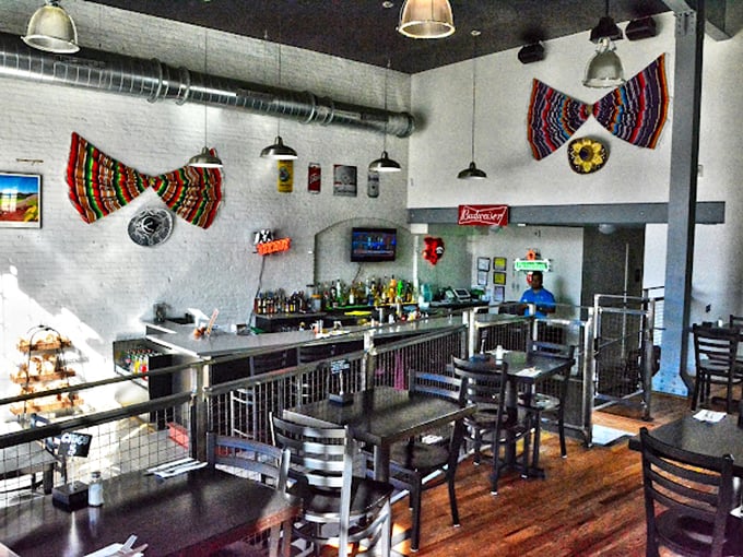 Industrial meets homey in this bright interior where white walls serve as the perfect canvas for colorful Mexican textiles. The minimalist design keeps the focus where it belongs &ndash; on the food.