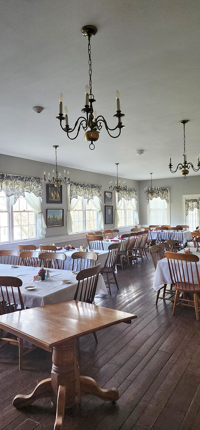 Period-appropriate chandeliers cast a warm glow over Windsor chairs and wooden tables that have welcomed diners for nearly two centuries.
