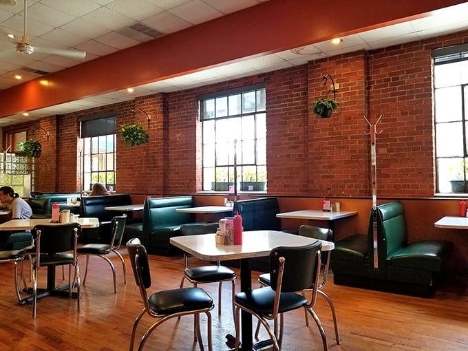 Exposed brick walls, hanging plants, and classic green booths create that perfect diner atmosphere where conversations flow as freely as the coffee.