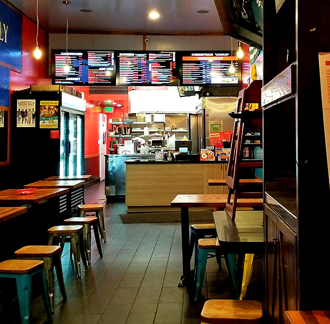 Inside Jake's, the vibrant red walls and industrial-chic seating create an atmosphere that's equal parts Philly sports bar and San Francisco cool.