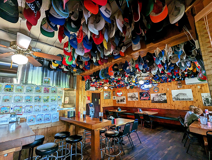 Baseball caps by the thousands create the world's most colorful ceiling—each one a story, a memory, a testament to burgers well-enjoyed.