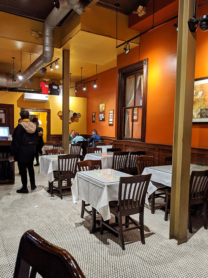 Warm orange walls and white tablecloths create that perfect sweet spot between "fancy enough for date night" and "comfortable enough to lick your fingers."