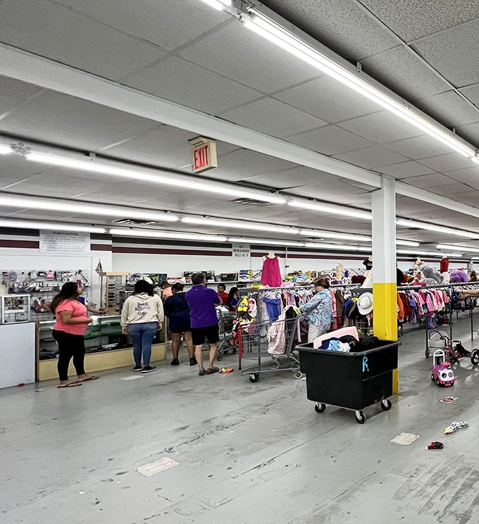 Treasure hunters navigate the vast expanse of World Thrift's interior. The fluorescent lighting illuminates what might be Florida's most ambitious collection of secondhand possibilities.