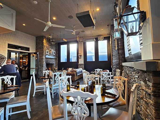 Where rustic meets refined: Stone walls, elegant white chairs, and thoughtful lighting create a dining room that feels like the sophisticated country retreat you never knew you needed.