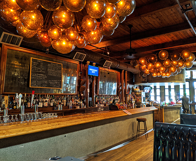 Amber globes float like whiskey-colored planets above the bar. This isn't just lighting&mdash;it's mood engineering at its finest.