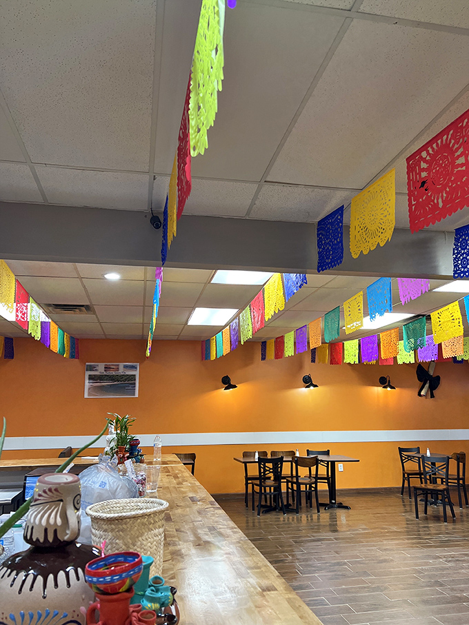 Colorful papel picado banners dance overhead, transforming an ordinary ceiling into a perpetual fiesta. The vibrant orange walls radiate warmth even on Ohio's grayest days.