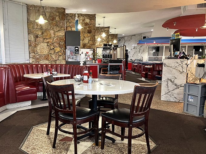 Red vinyl booths and stone walls create the perfect backdrop for comfort food conversations. This isn't decoration—it's dining history.