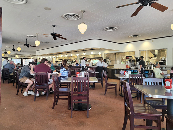 Inside, ceiling fans lazily spin above wooden chairs and tables where culinary dreams come true. The open kitchen invites you into the delicious drama.