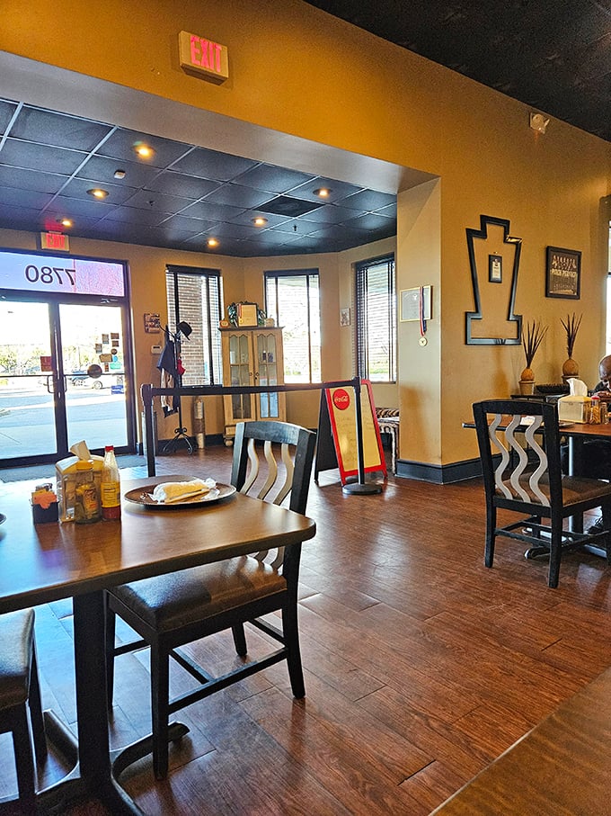 The dining area offers simple comfort with warm yellow walls and wooden accents&mdash;where the focus remains squarely on what fills your plate.