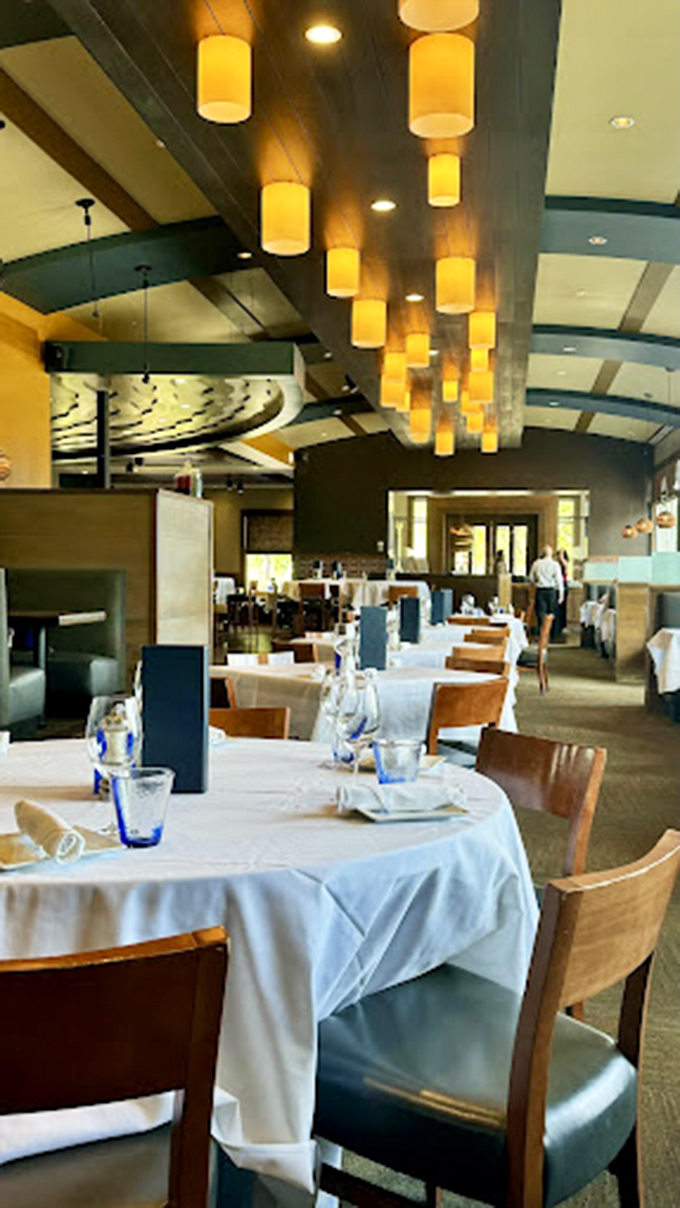 The dining room's warm amber lighting creates an atmosphere that says "special occasion" while the comfortable seating whispers "stay awhile." 