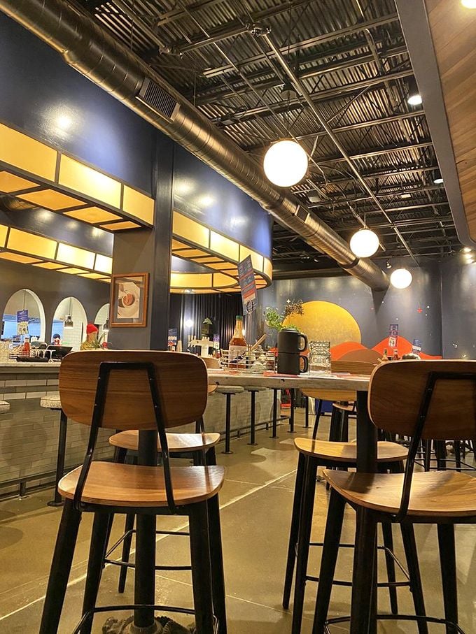 Industrial chic meets cozy comfort in this thoughtfully designed space where wooden chairs and exposed ductwork create the perfect backdrop for serious eating.