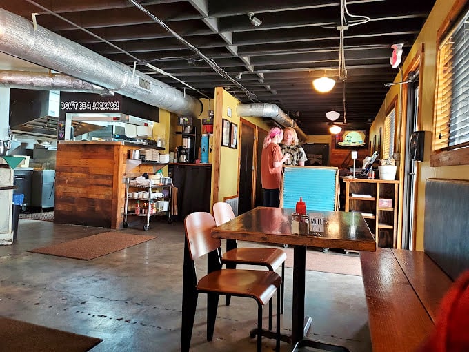 Industrial-chic meets cozy comfort in The Mule's thoughtfully designed interior. Exposed ductwork overhead, wooden tables below, and the promise of melted cheese everywhere in between.