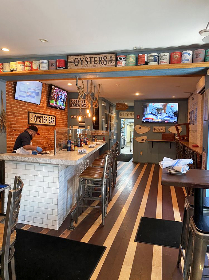Inside, vintage oyster cans crown shelves above a bar where seafood dreams come true. The striped wood floor mimics boardwalk planks—a clever nod to the shore.