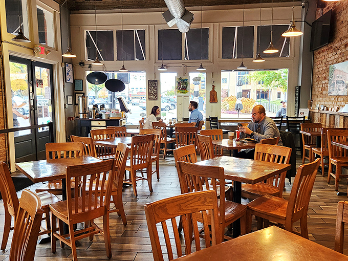 Wooden chairs, exposed brick, and natural light create the perfect backdrop for breakfast conversations that linger long after the plates are cleared.