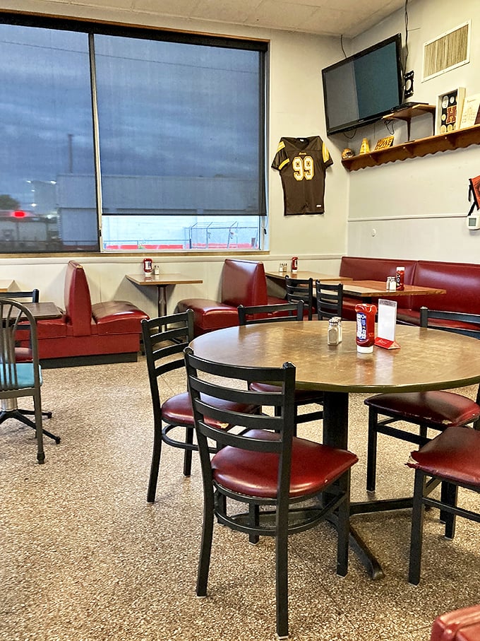 Red vinyl booths and terrazzo floors tell stories of countless meals shared, while a football jersey watches over diners like a friendly ghost.