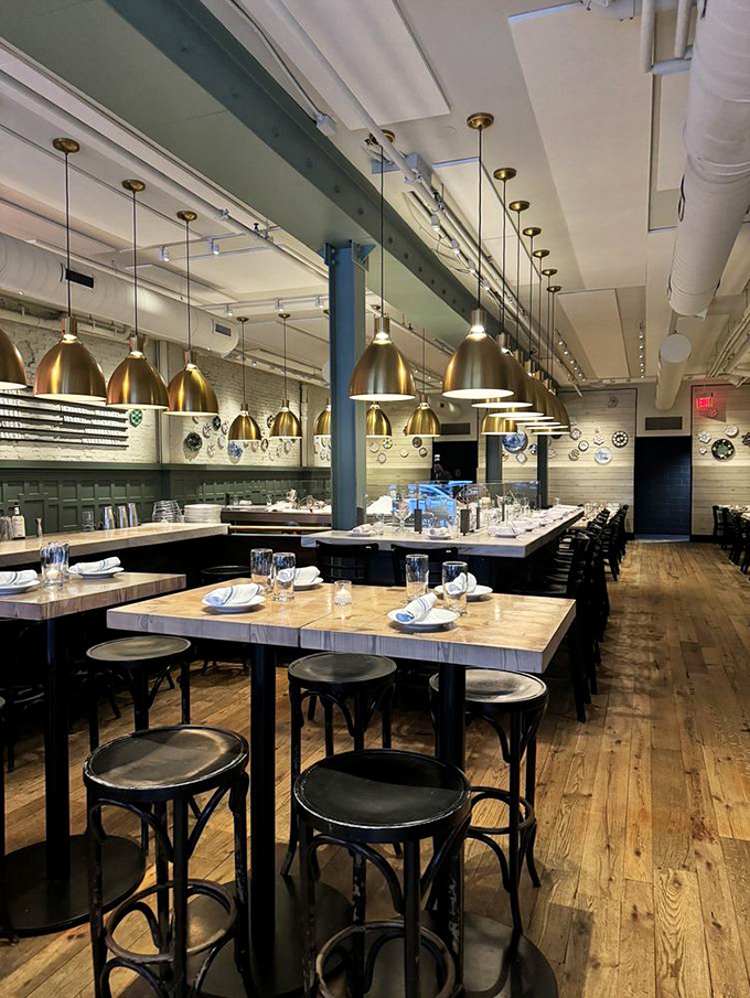 The dining room perfectly balances nautical charm with modern elegance. Those brass pendant lights could moonlight as props in a Wes Anderson film about fancy submarines.