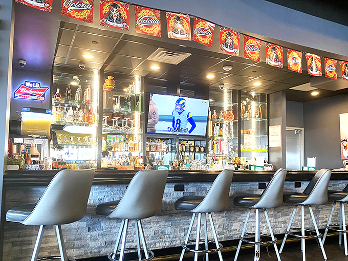 The modern bar area marries contemporary design with fiesta spirit. It's where margaritas flow and game-day camaraderie thrives.