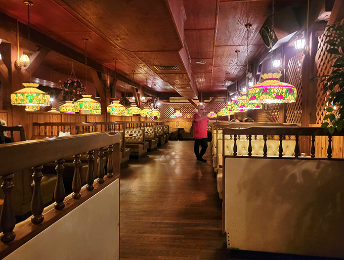 Vintage Tiffany-style lamps cast a warm glow over wooden booths, creating an atmosphere where conversations flow as smoothly as the drinks.