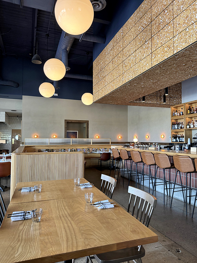 Soaring ceilings, globe pendant lights, and natural wood create a space that's simultaneously modern and timeless&mdash;like comfort food with a college degree.