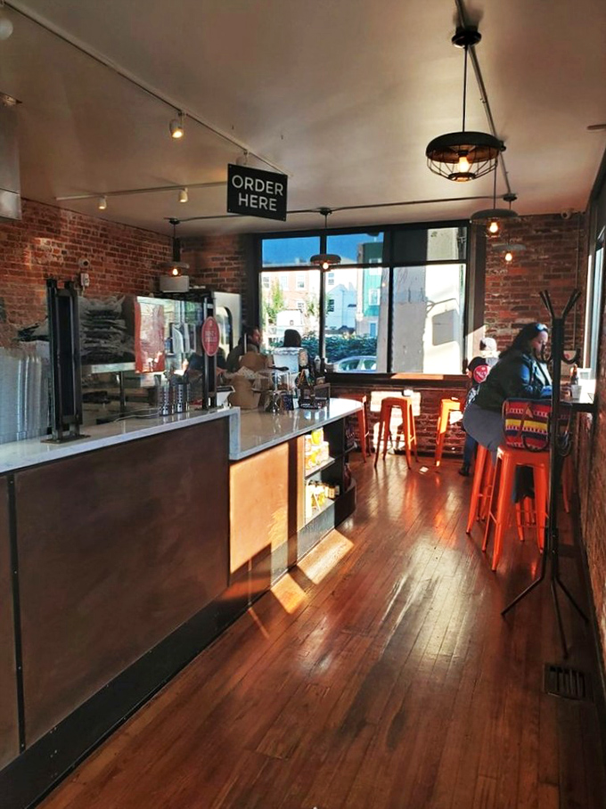 Warm wooden floors, exposed brick, and industrial lighting create the perfect stage for fried chicken that deserves its own Broadway show.
