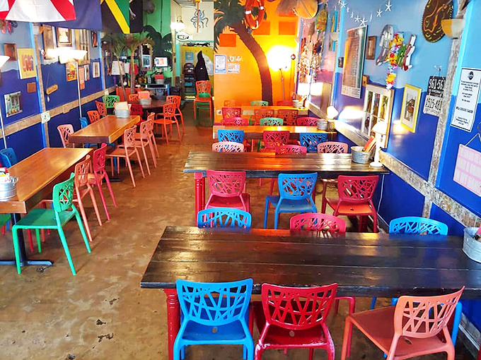 A kaleidoscope of colorful chairs welcomes diners into a space where every day feels like vacation. Blue walls, vibrant seating, and beach vibes galore.