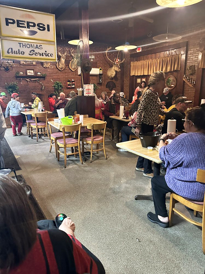 Vintage signs and mounted trophies create that authentic small-town atmosphere where conversations flow as freely as the sweet tea.