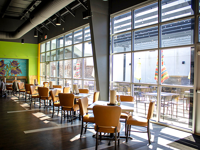 Sunlight floods through floor-to-ceiling windows, illuminating a space where colorful walls and comfort merge. This isn't just dining&mdash;it's a mood elevator.