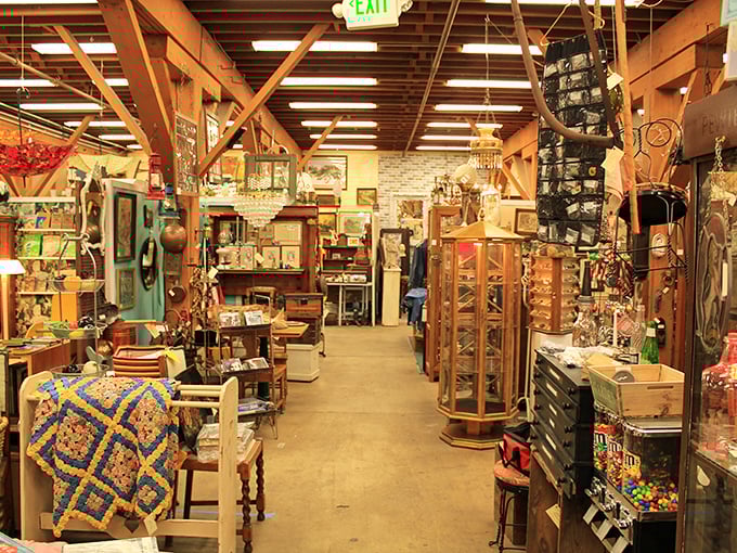 Wooden beams frame pathways between worlds, each booth a chapter in America's material autobiography. The quilt on the left? Someone's grandmother made that.