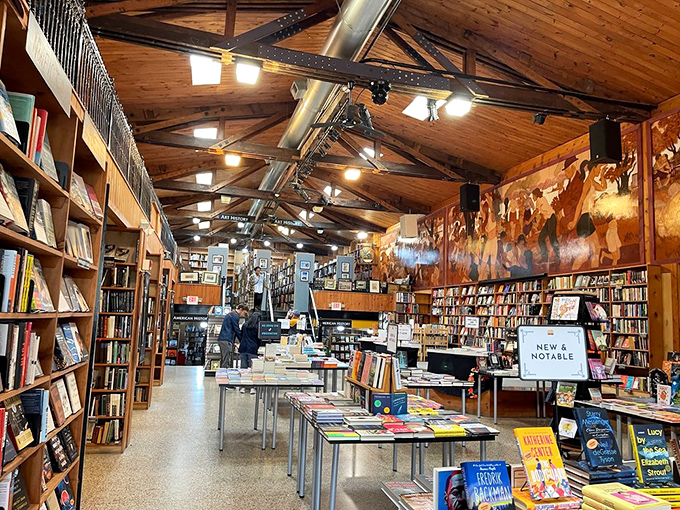 Wooden ceiling beams frame literary paradise. Like a cathedral for book lovers, the interior welcomes you with the promise of discoveries waiting.