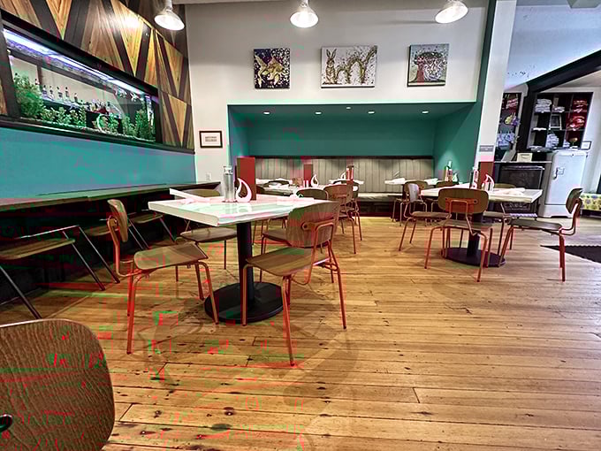 Wooden floors that have seen decades of history meet modern teal accents and playful red chairs&mdash;comfort with just the right amount of style.