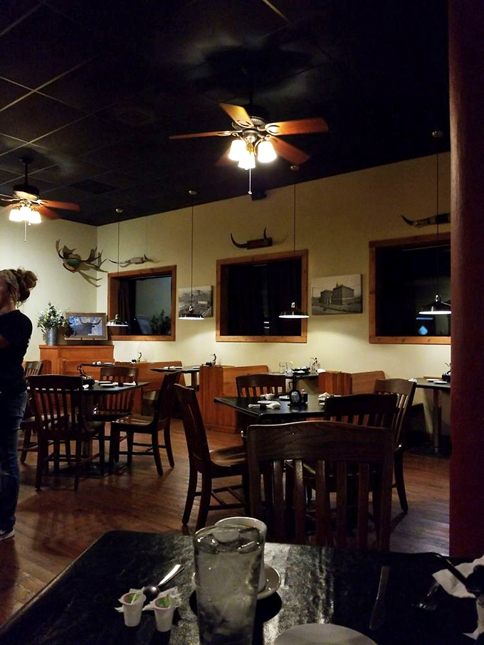 The dining room whispers "serious steak business" with its warm lighting, wooden accents, and antler mounts. This is comfort incarnate.