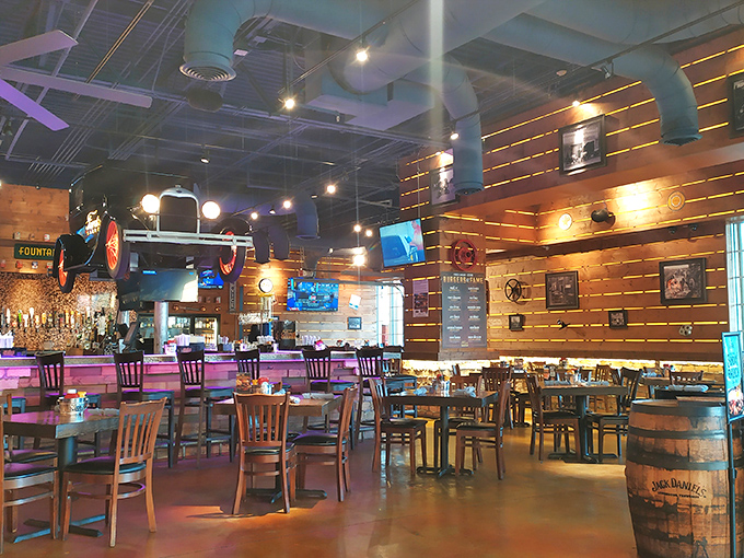 Step inside and you're transported to a world where Edison-style lighting illuminates wooden barrels, automotive memorabilia, and hungry patrons enjoying the perfect blend of garage chic and culinary comfort.